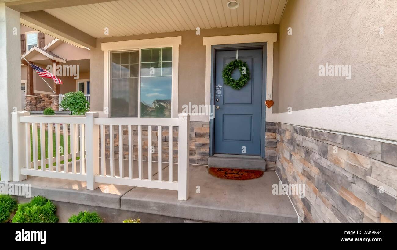 Pano frame Facade of a home with railing on the porch and front door ...