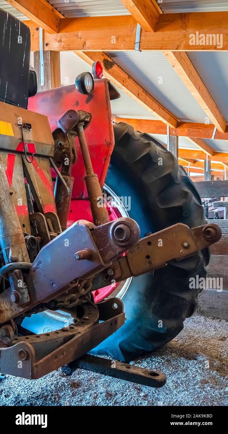 Vertical frame Back view of an old vintage tractor with black wheels ...