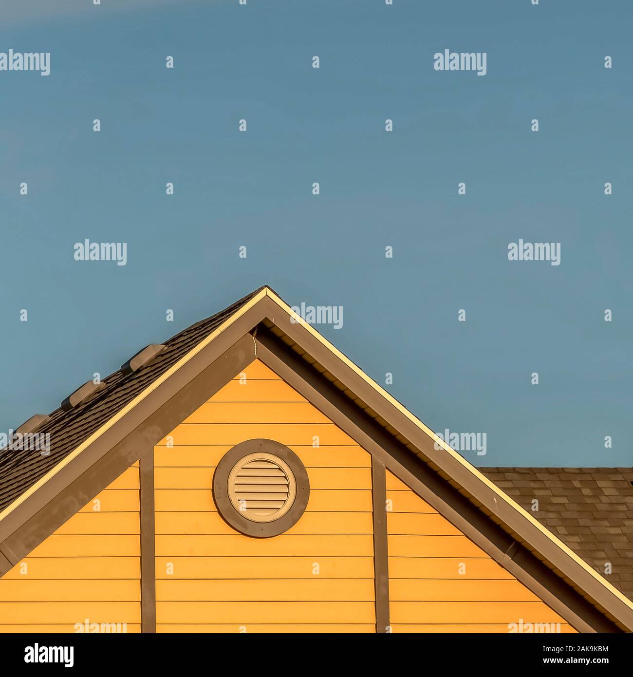 Square frame House exterior with roof shingles and round gable window ...