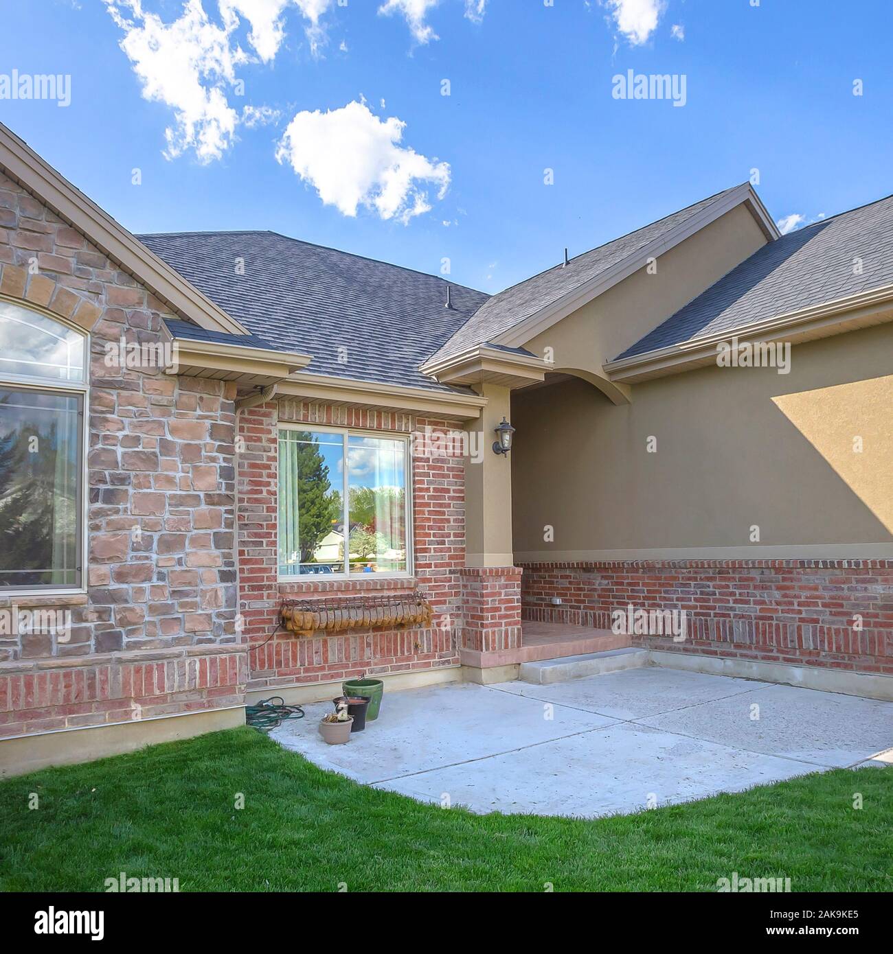 Square frame Beautiful exterior of home with brick wall landscaped yard ...