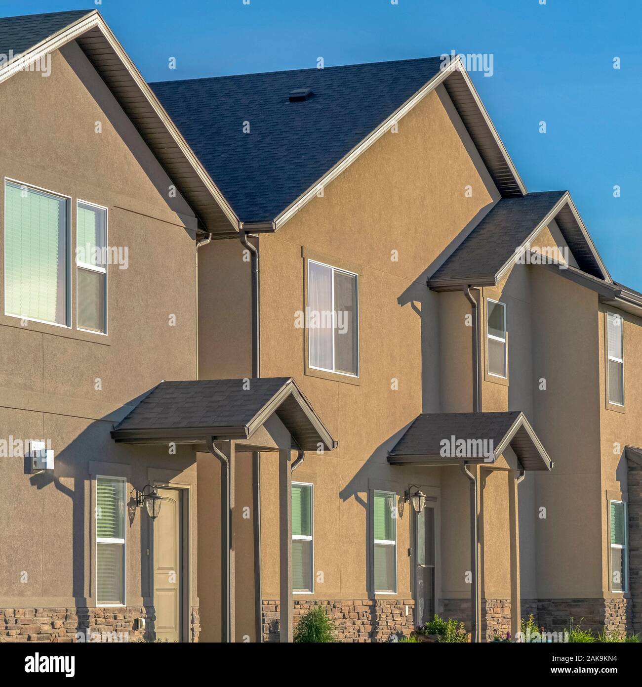 Square Facade of homes with concrete and brick wall and porticos at the ...