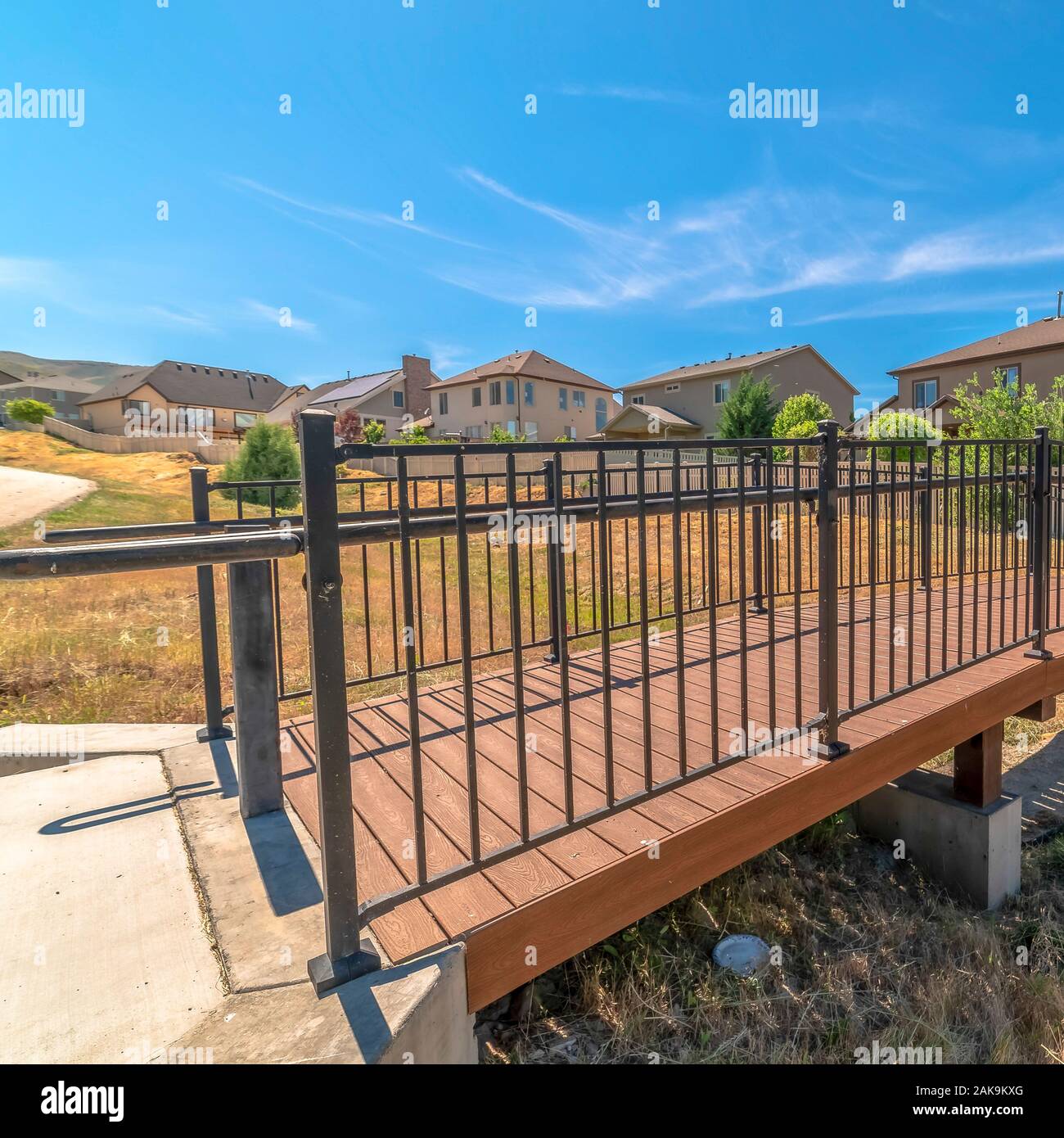 Square frame Side view of a bridge over a grassy terrain with homes and ...