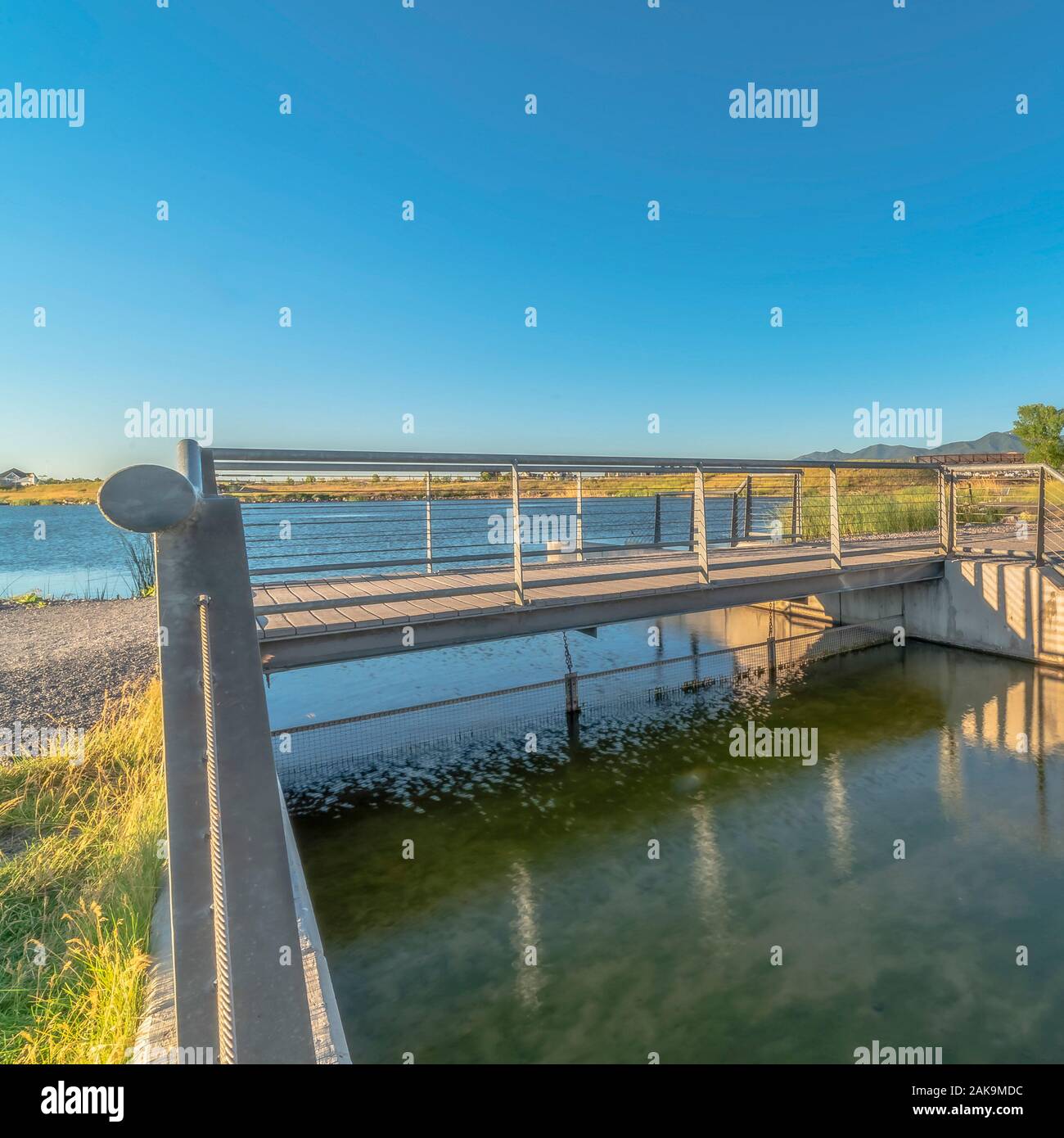 Square frame Bridge over lake with lakefront buildings and mountain ...
