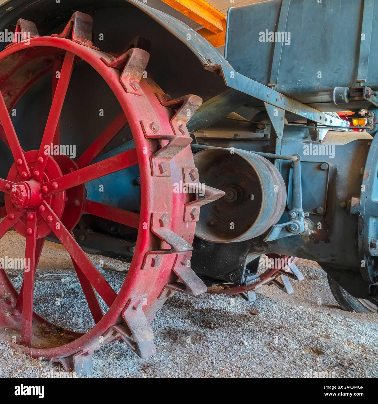 Square frame Red wheel rim of an and vintage tractor against stone wall ...