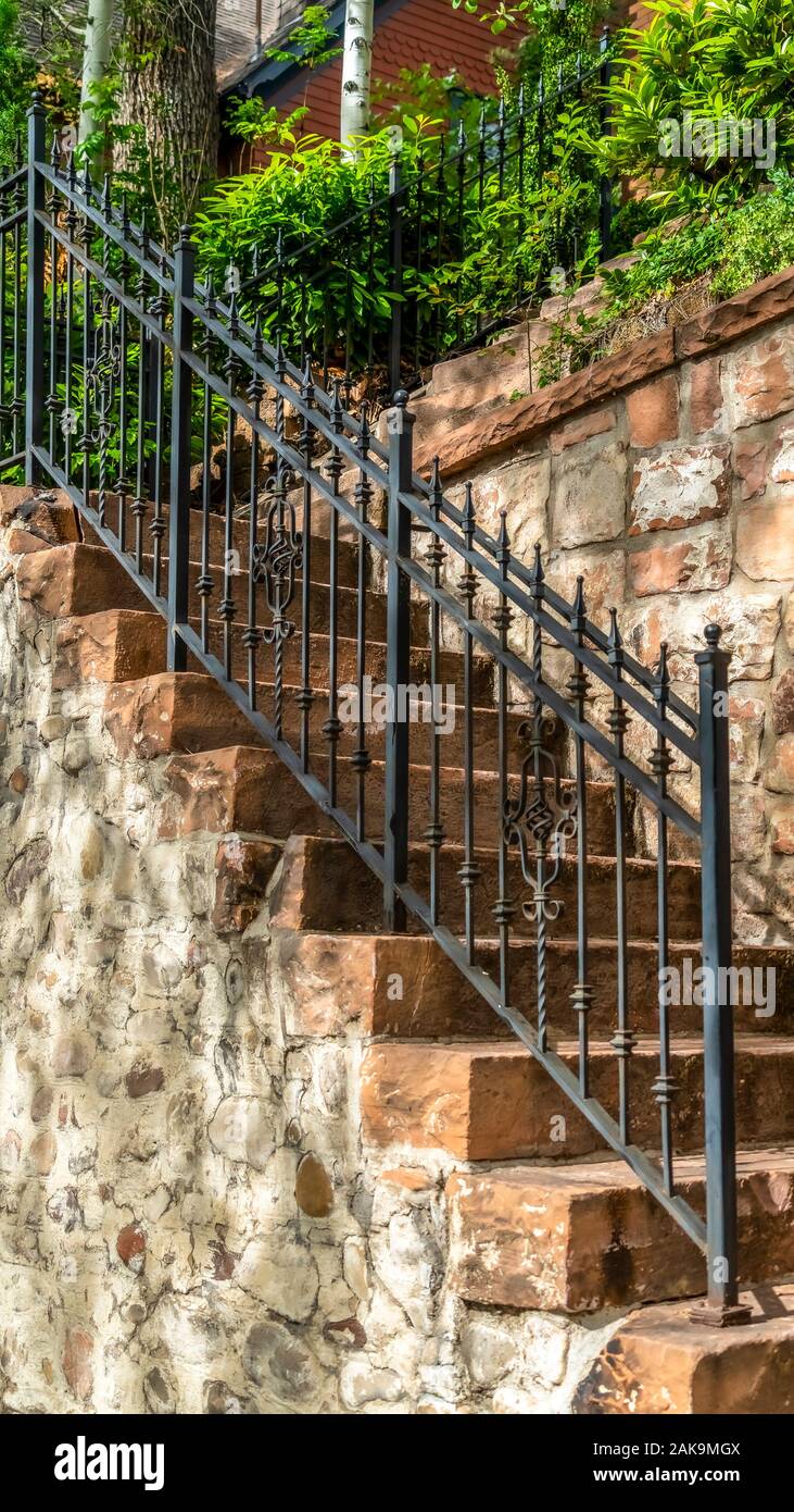 Vertical Outdoor staircase with stone steps and black metal railing ...