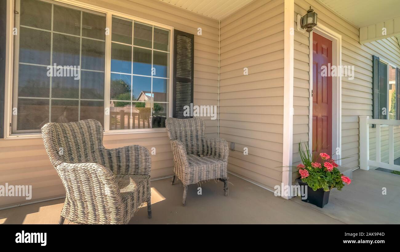 Pano frame Wicker armchairs on the sunlit front porch of home with ...