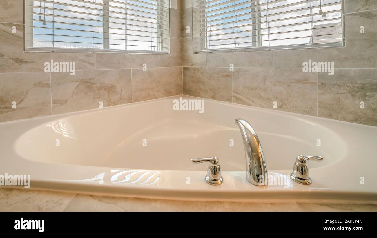 Pano frame Close up of a bathtub in a bathroom with marble tile wall ...
