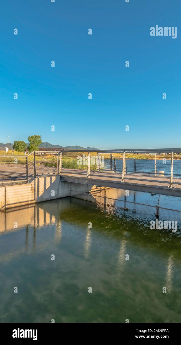 Vertical frame Bridge over lake with lakefront buildings and mountain ...