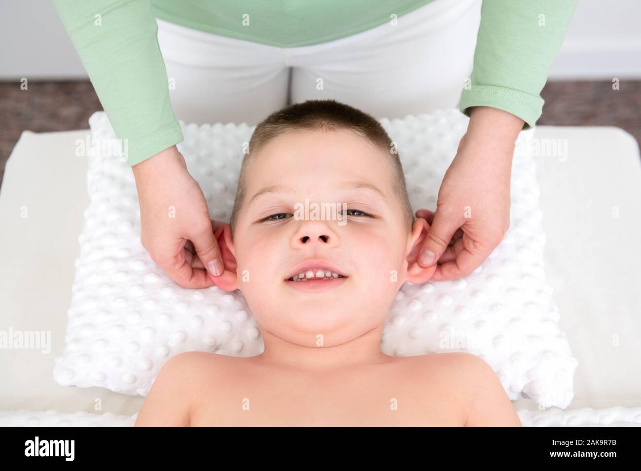 Kids massage concept background. Female therapist giving a young boy ...
