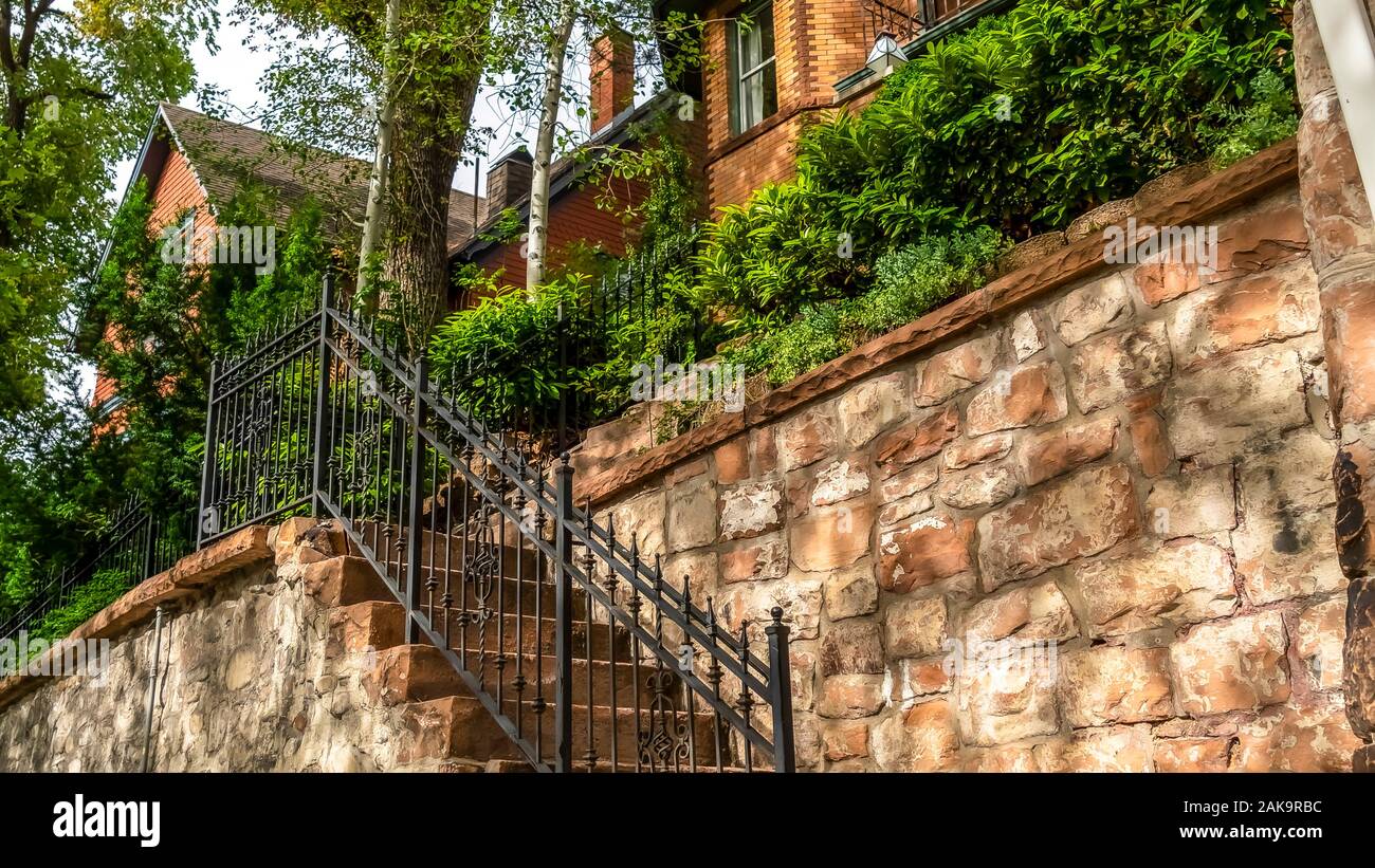 Pano frame Outdoor staircase against stone fence of home with red brick ...