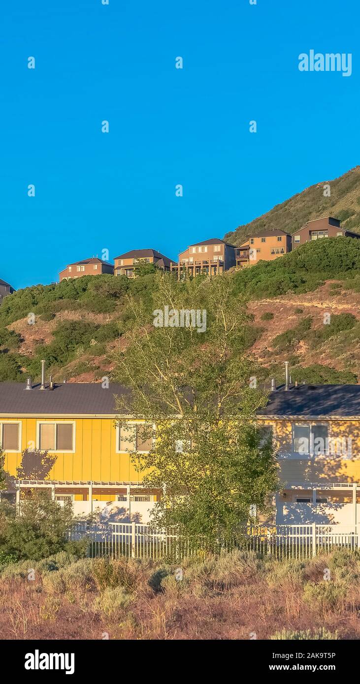Vertical frame Scenic sunny day view of houses built on a mountain with ...