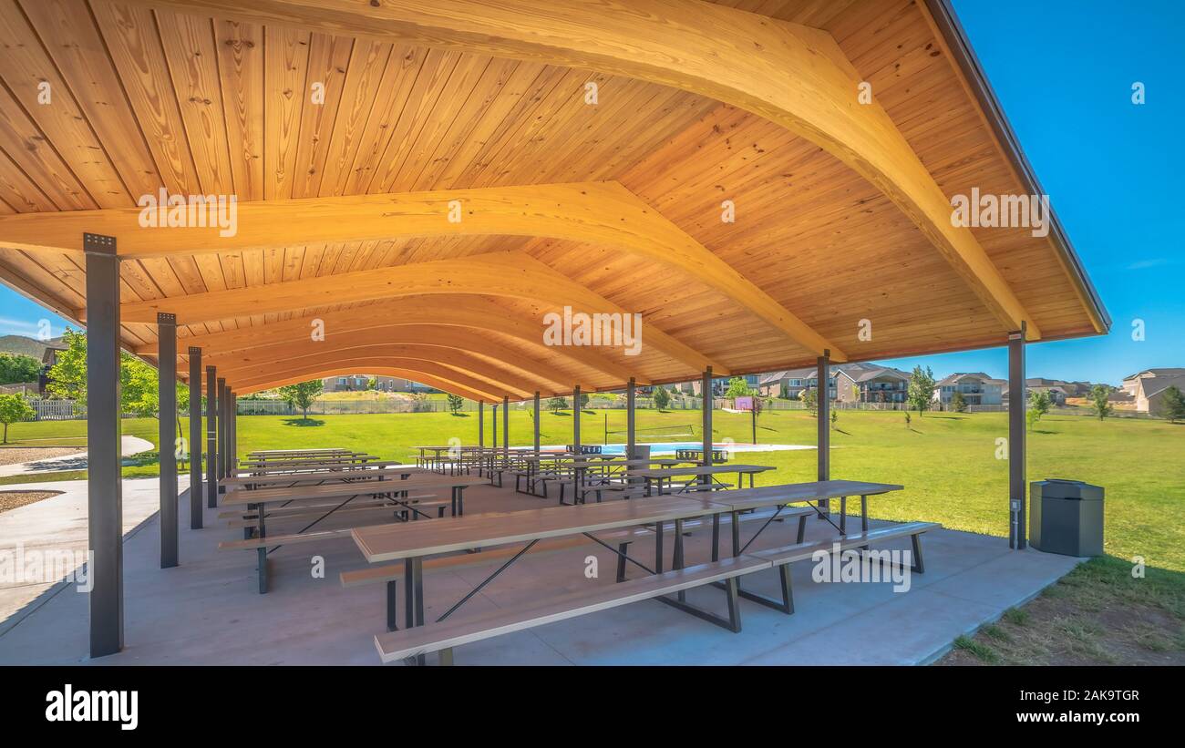 Pano Sunny day views at a park with pavilion and basketball court under ...