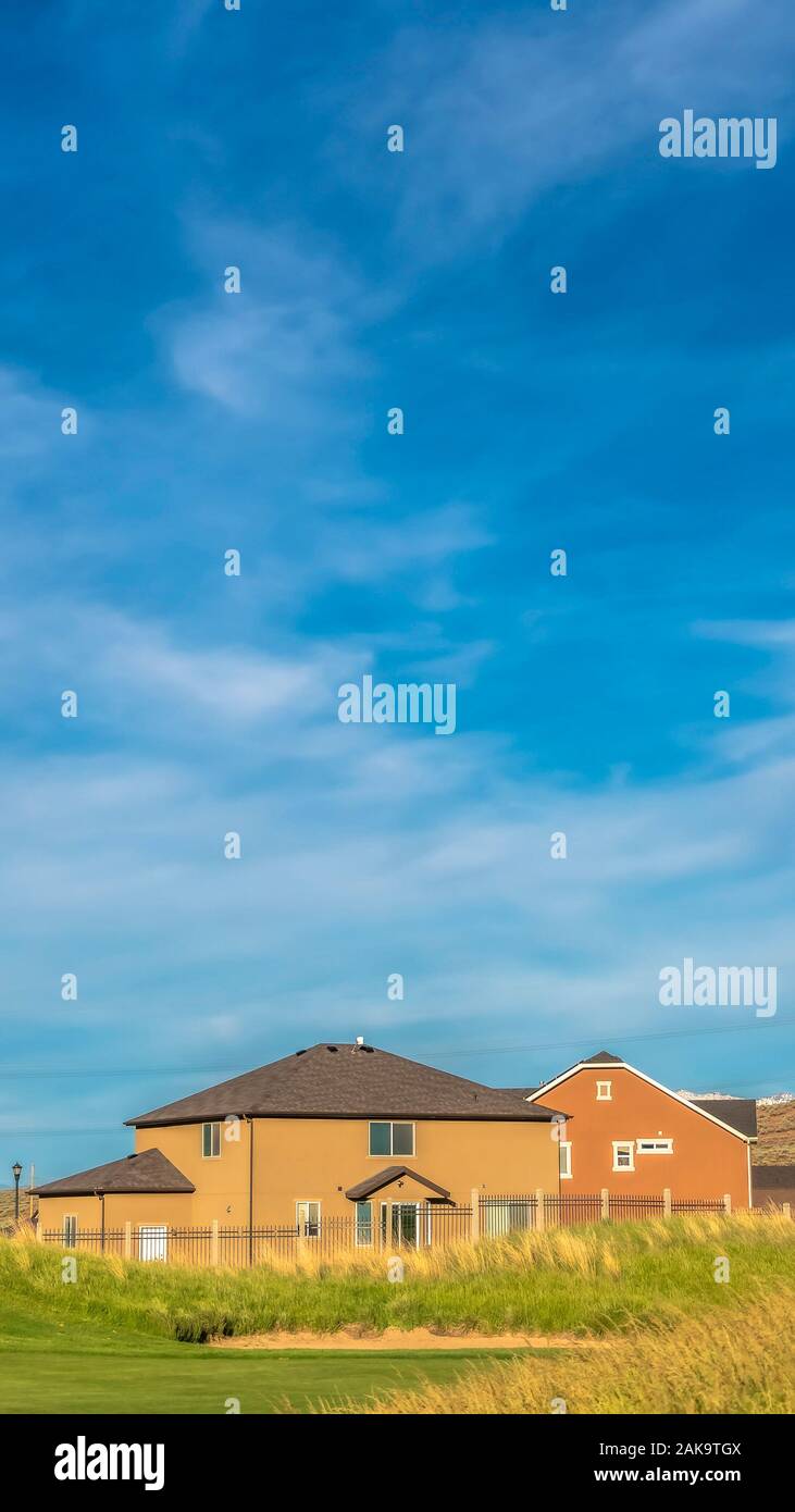 Vertical Green grasses of golf course with houses and mountain in the ...