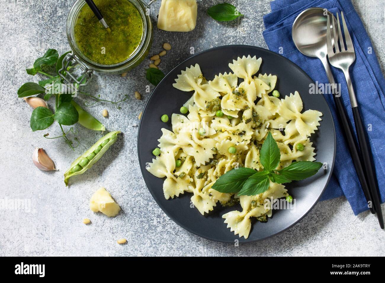 Healthy Italian cuisine. Pasta with green peas and pesto sauce in black ...