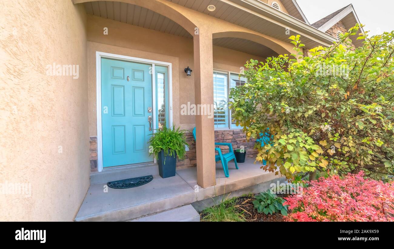 Pano frame Home with stairs that leads to arched porch and blue front ...