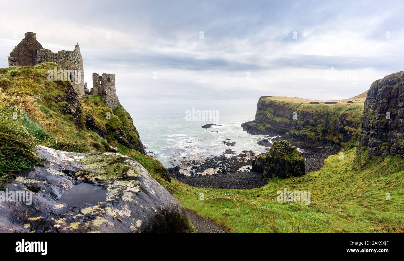 Ruined medieval Dunluce Castle on the cliff in Bushmills town. Filming ...