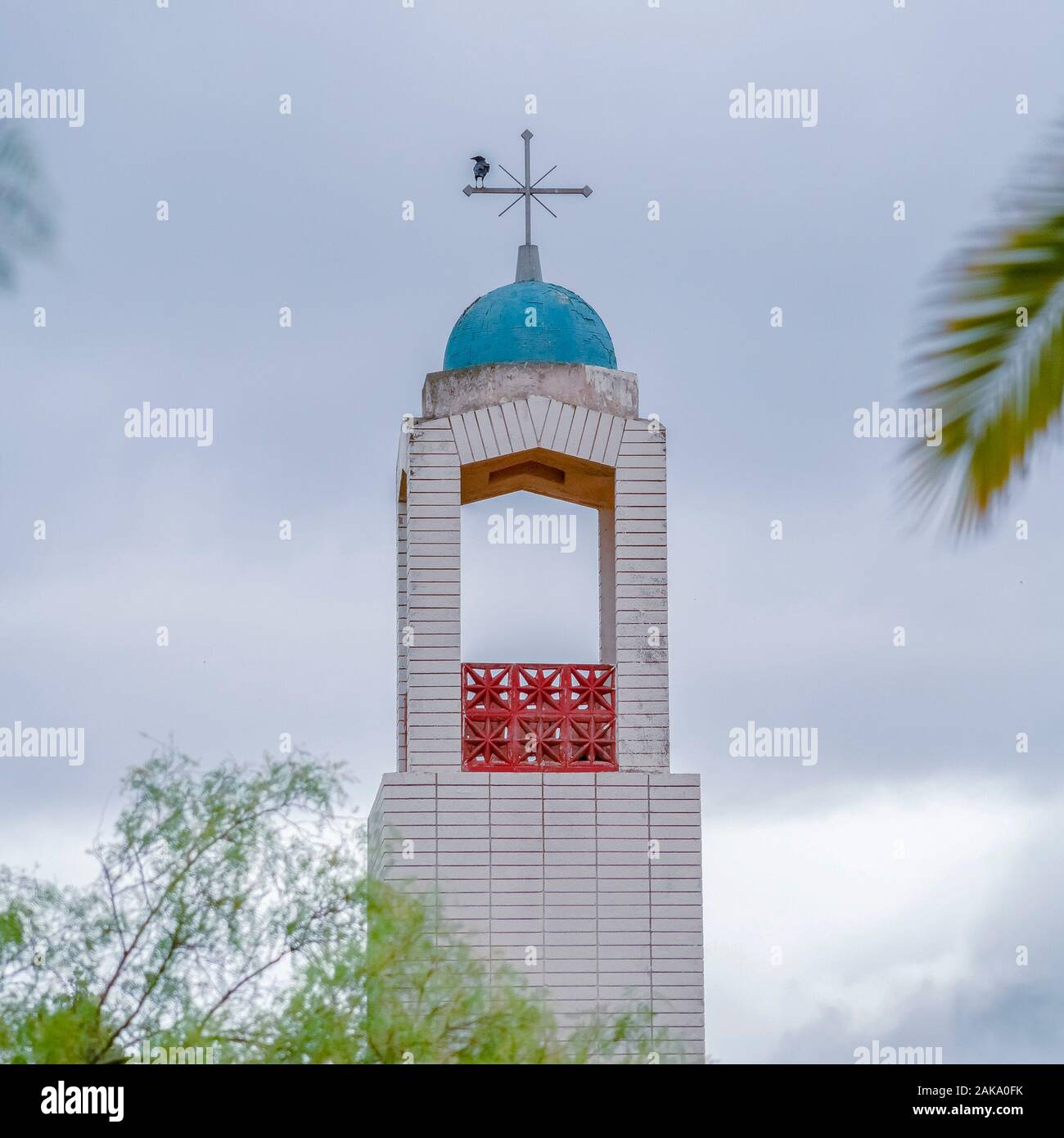 Square frame Bell tower of a small church above trees Stock Photo - Alamy