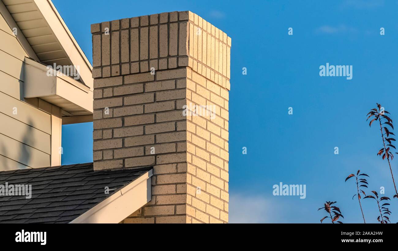 Panorama Feature brick chimney on a house exterior Stock Photo - Alamy