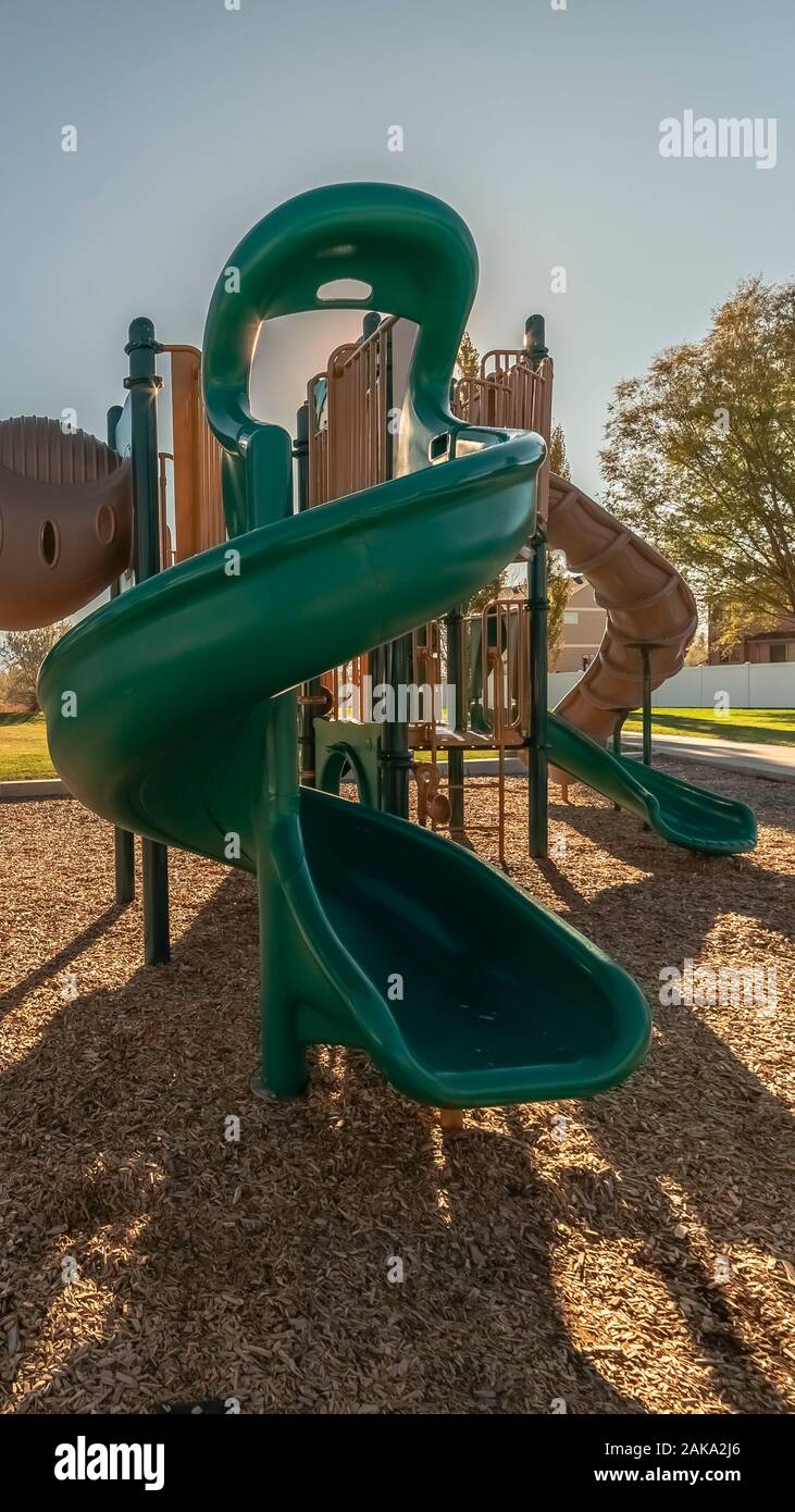 Vertical frame Kids playground at sunset with twist slide Stock Photo ...
