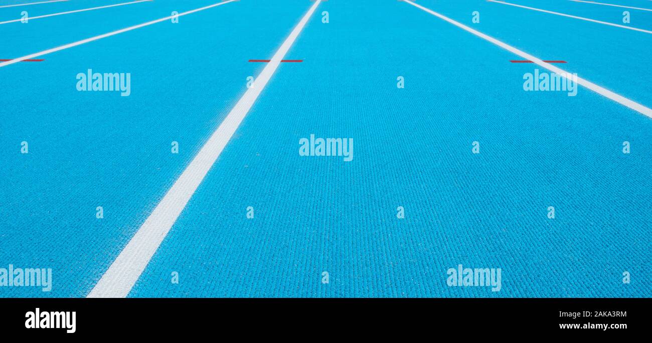 Blue running track with white lines and red mark in sport stadium. Top ...