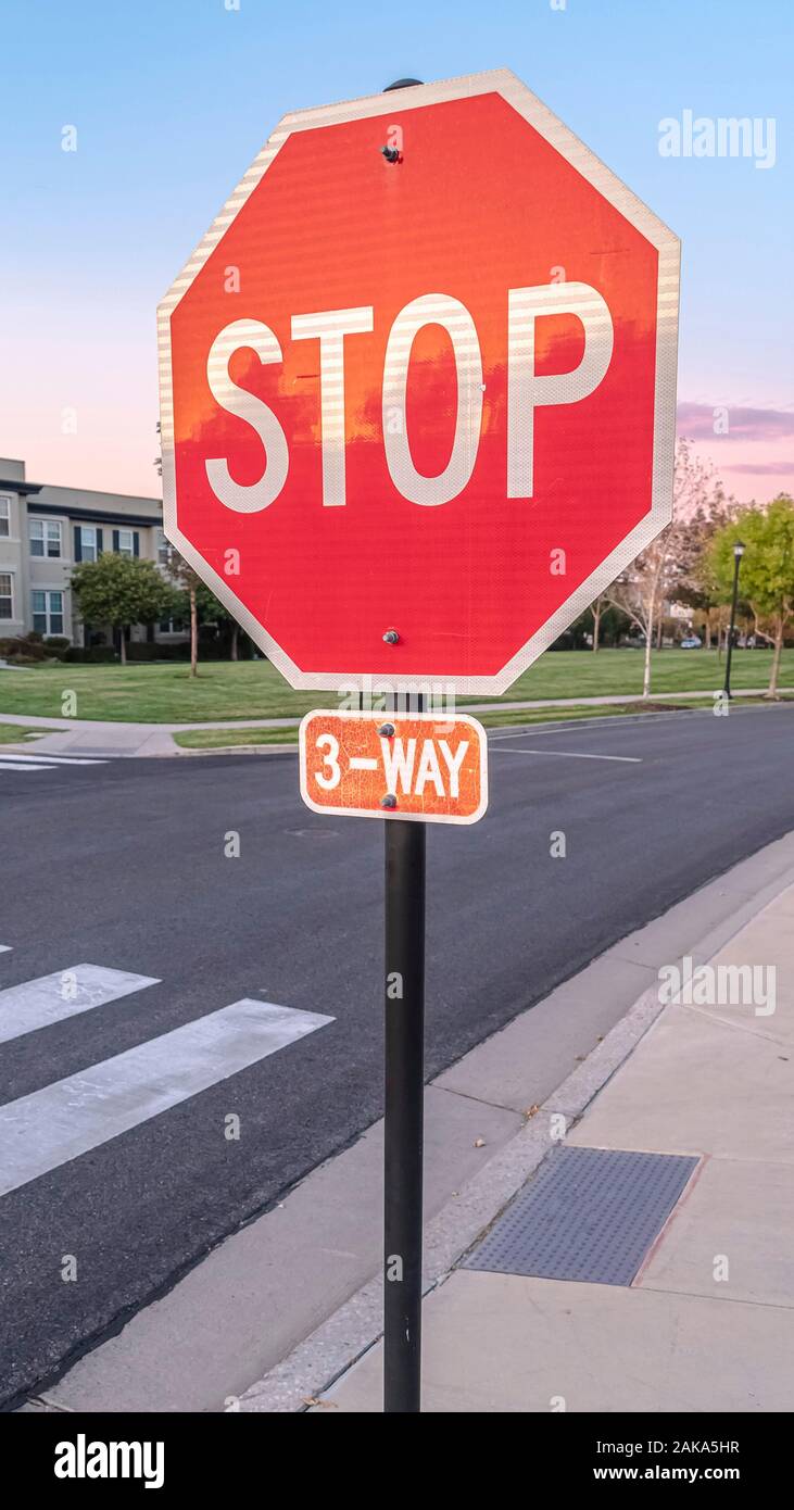 Vertical 3-Way Stop at a street intersection at sunset Stock Photo - Alamy