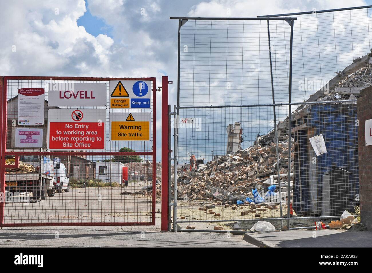 Warning and information signs on steel gates at entrance to demolition ...