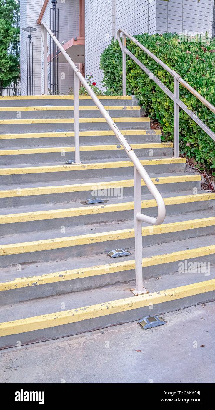 Vertical frame Cement entrance steps with yellow warning on a sunny day ...
