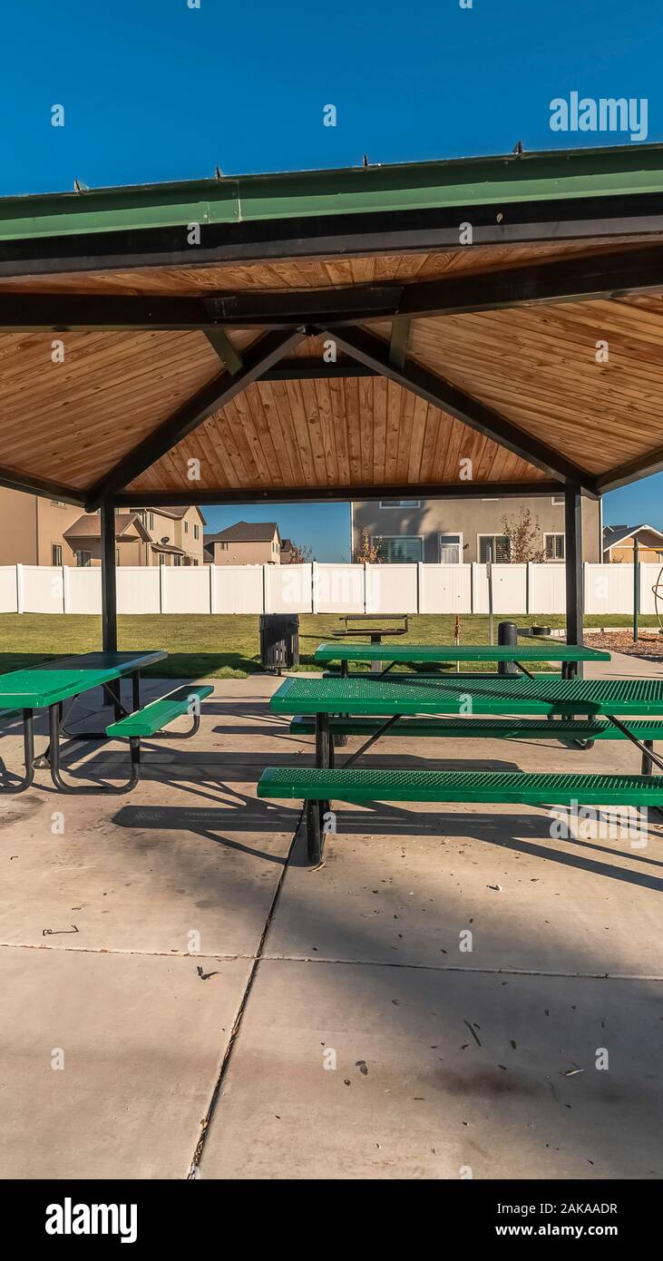 Vertical Picnic tables under a wooden roof in a park Stock Photo - Alamy