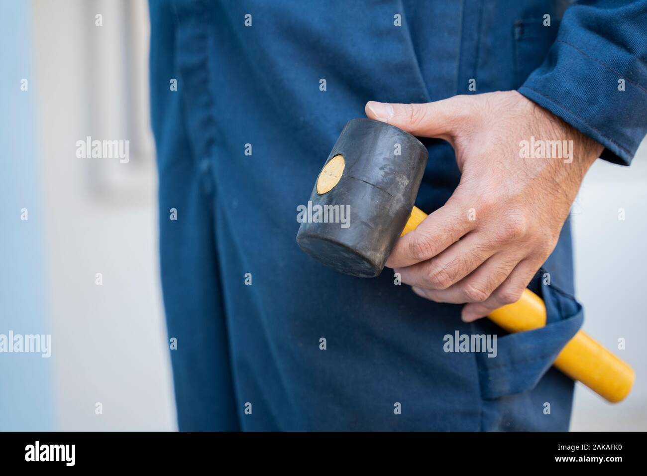 Mechanic engineer with rubber hammer Stock Photo - Alamy