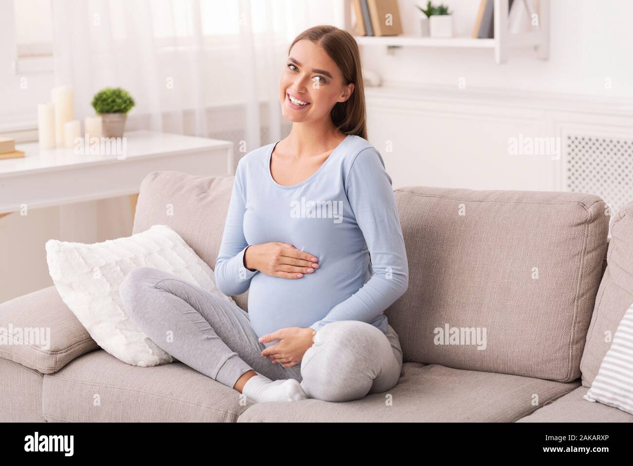 Happy Pregnancy. Cheerful Pregnant Girl Touching Belly Smiling Sitting ...