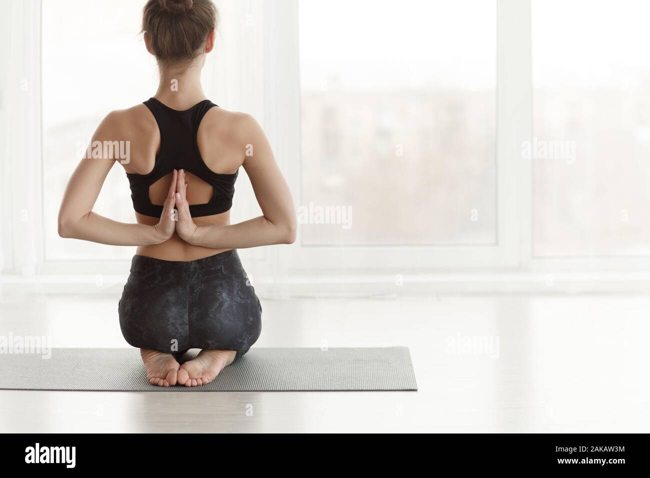 Fit woman doing yoga reverse prayer pose, back namaste, exercising in ...