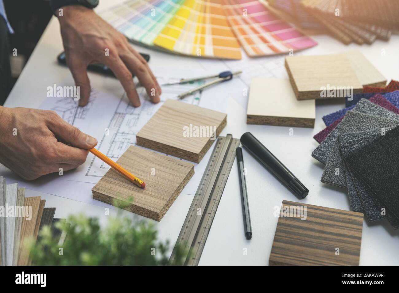 designer choosing flooring and furniture materials from samples for ...