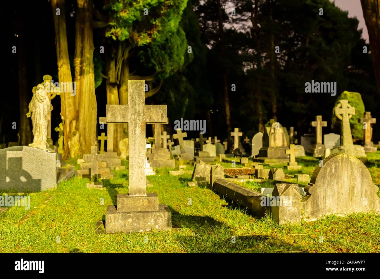 Colour night-time photograph within grave yard with grave stones ...