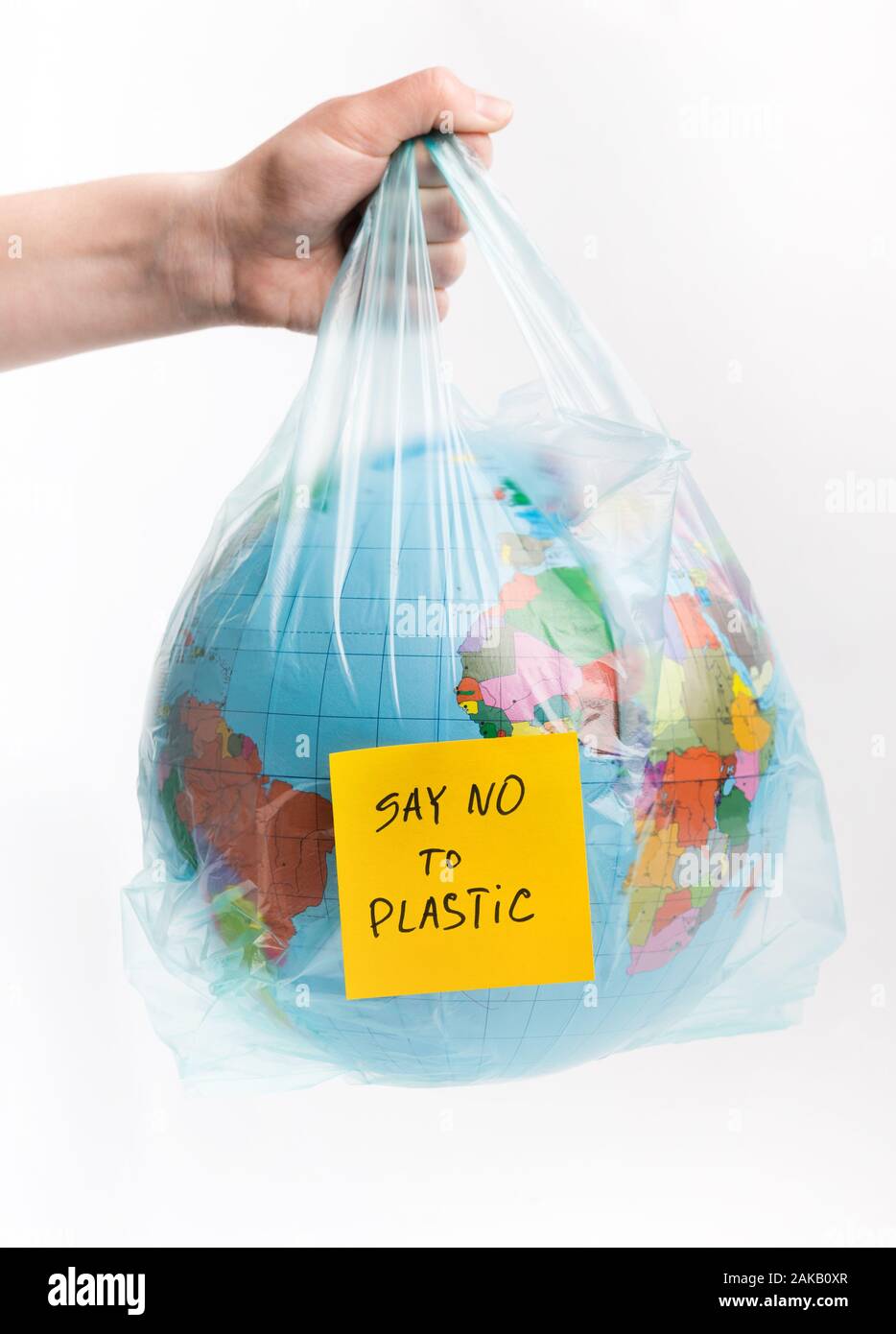 Say no to plastic. Human hand holding the earth in a plastic bag ...