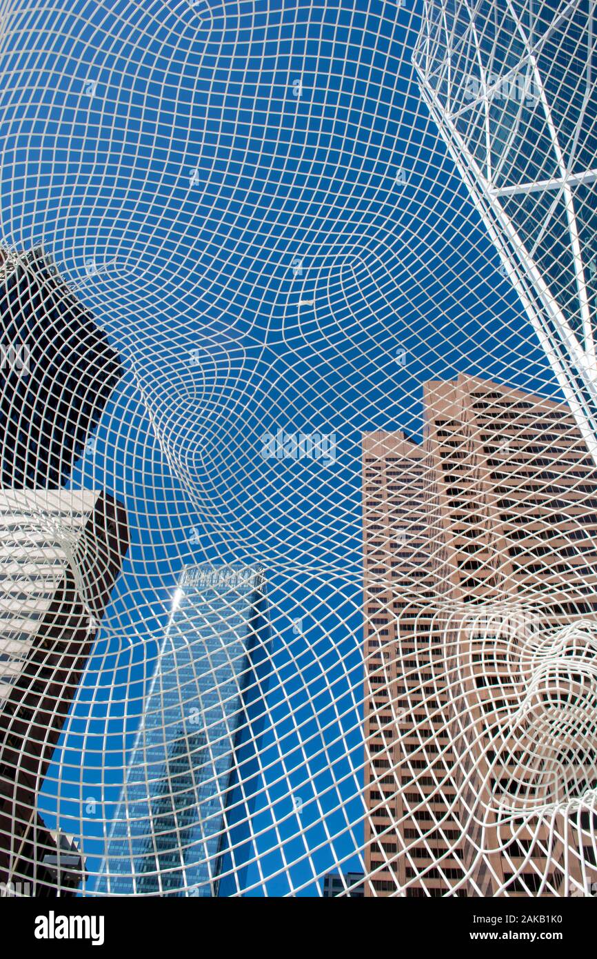 View through big mesh head public art display in front of office tower ...