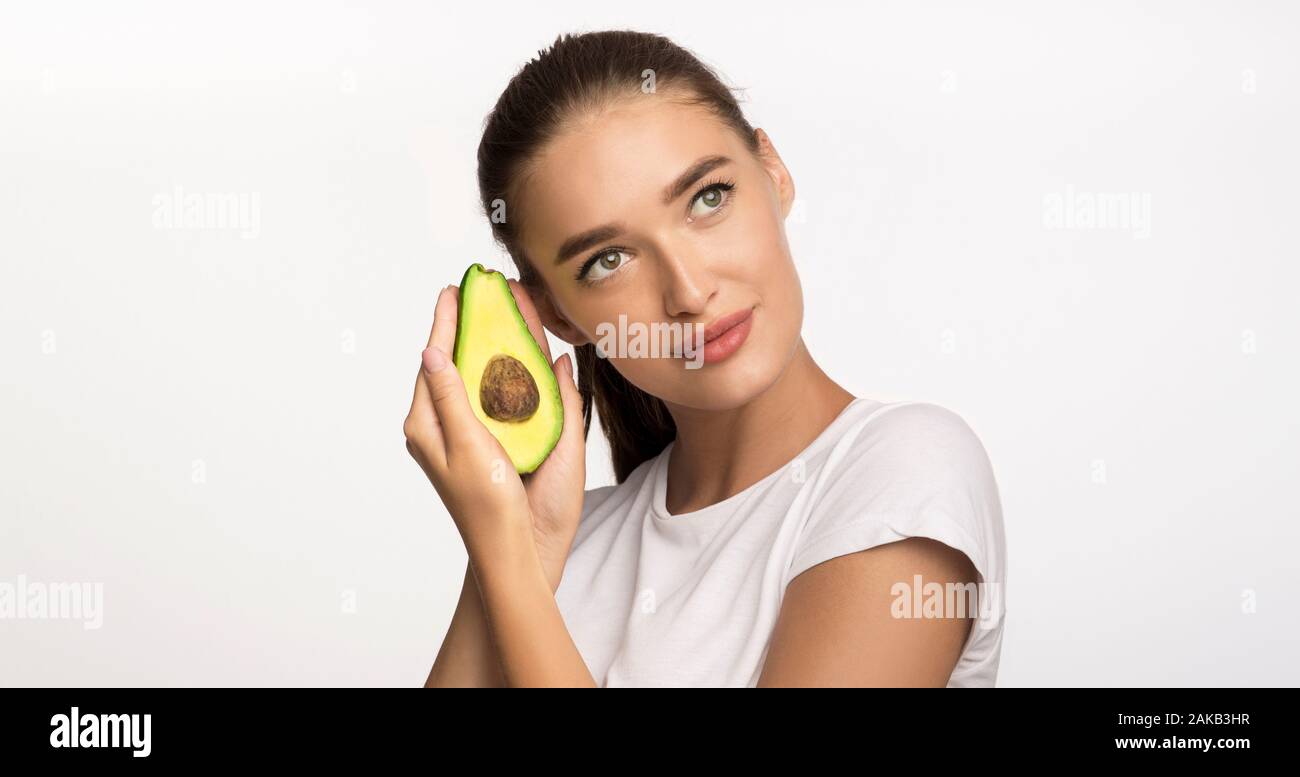 Beautiful Lady Holding Half Of Avocado Near Face Standing On White ...