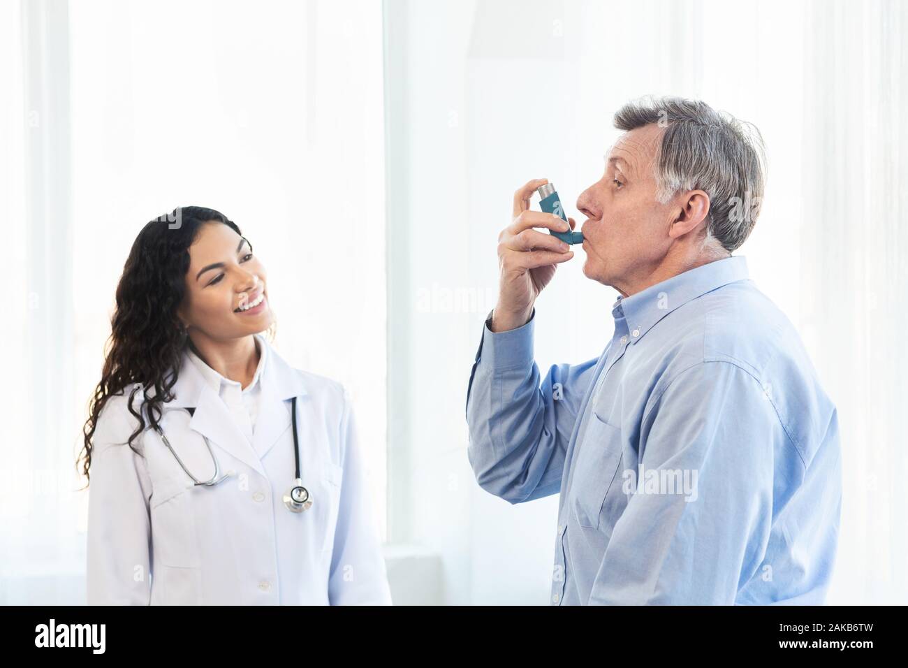 Medical Advice. Elderly man using asthma inhaler, mexican doctor ...