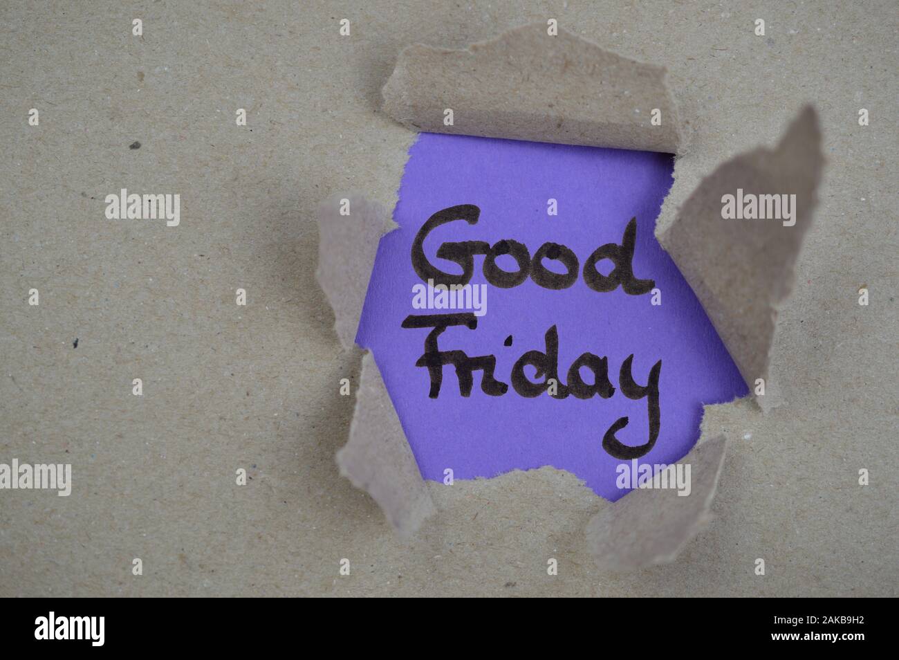 The words Good Friday on purple paper beneath ripped open gray packing ...