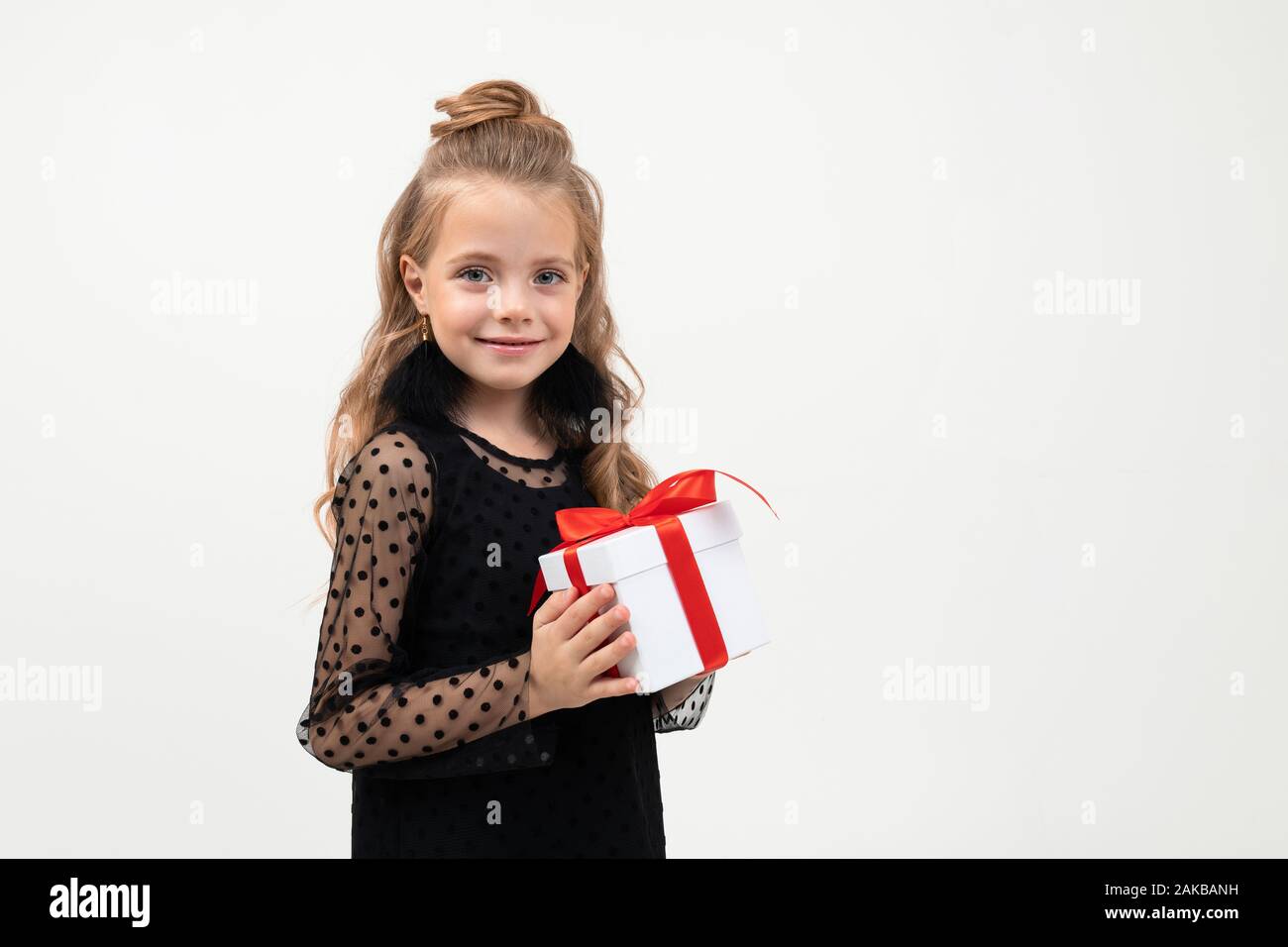 Caucasian girl holds white box with gift and smiles, portrait isolated ...