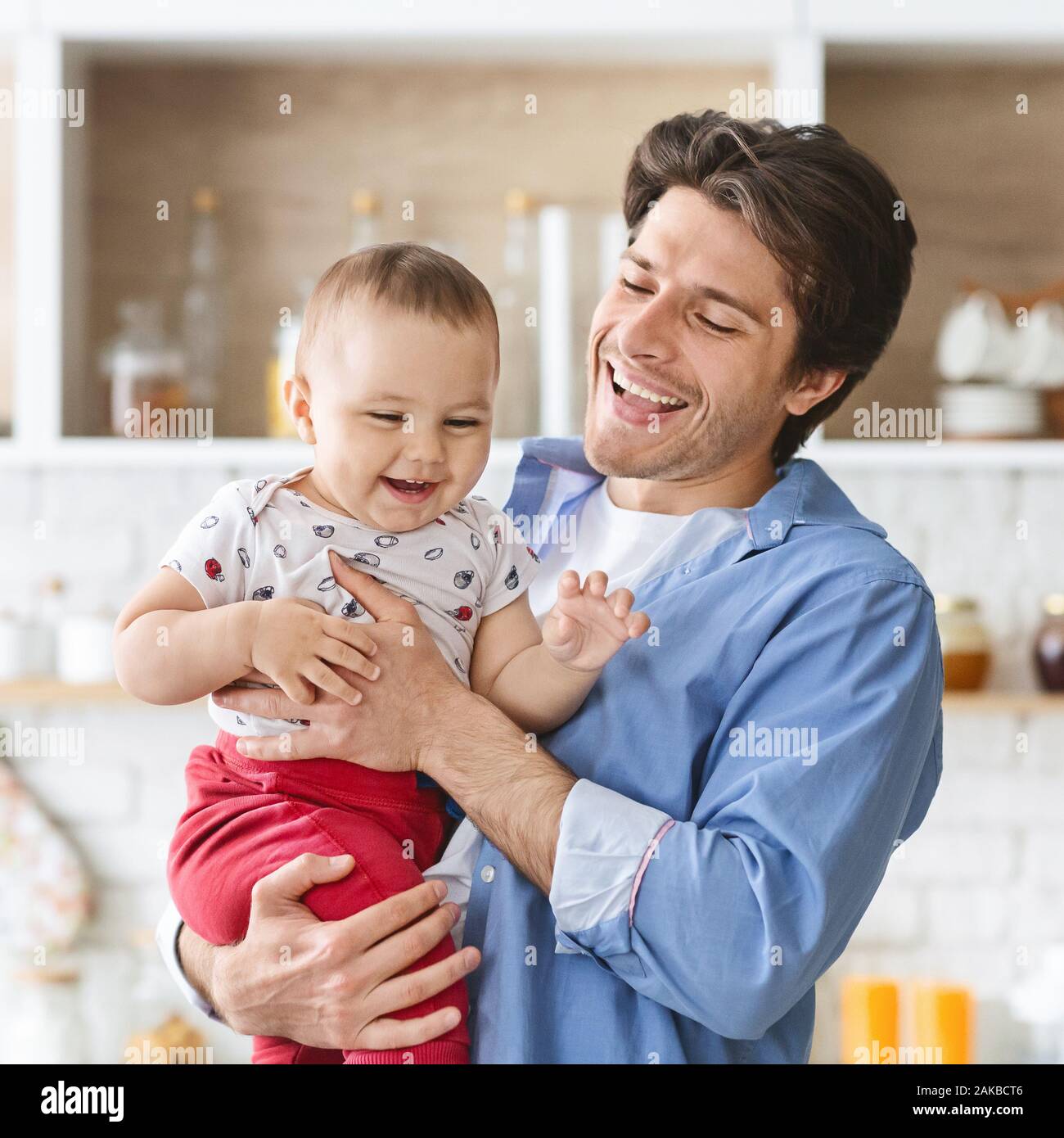 Happy father embracing his baby son with love, kitchen interior Stock ...