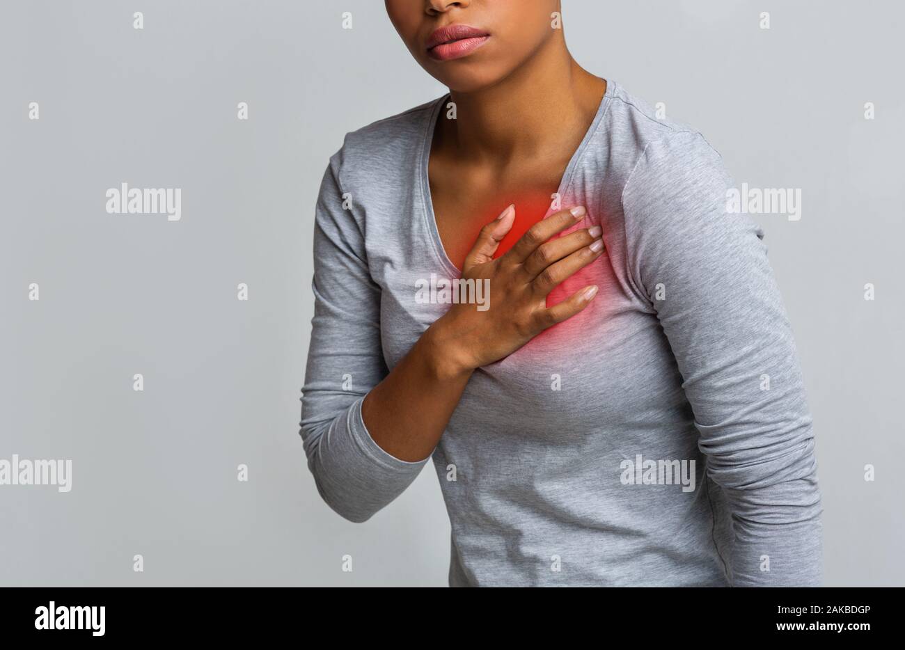 Cropped of afro woman suffering from acid reflux or heartburn ...