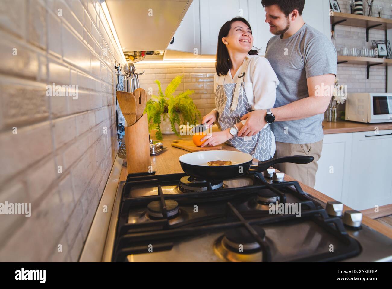 lovely couple hugging on the kitchen while cooking breakfast Stock ...