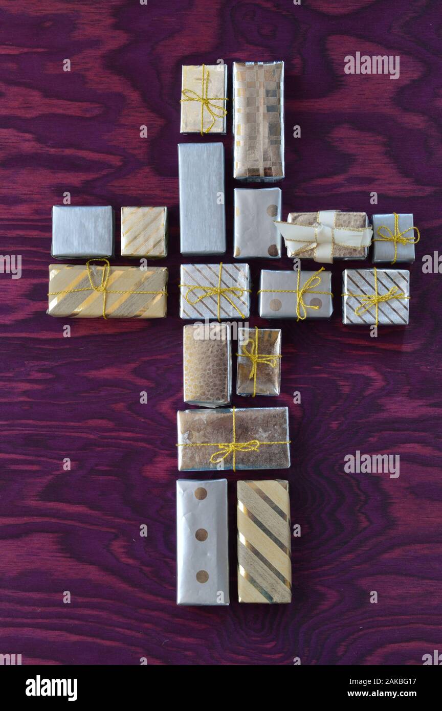 many little presents shaping a cross on purple wooden background Stock ...