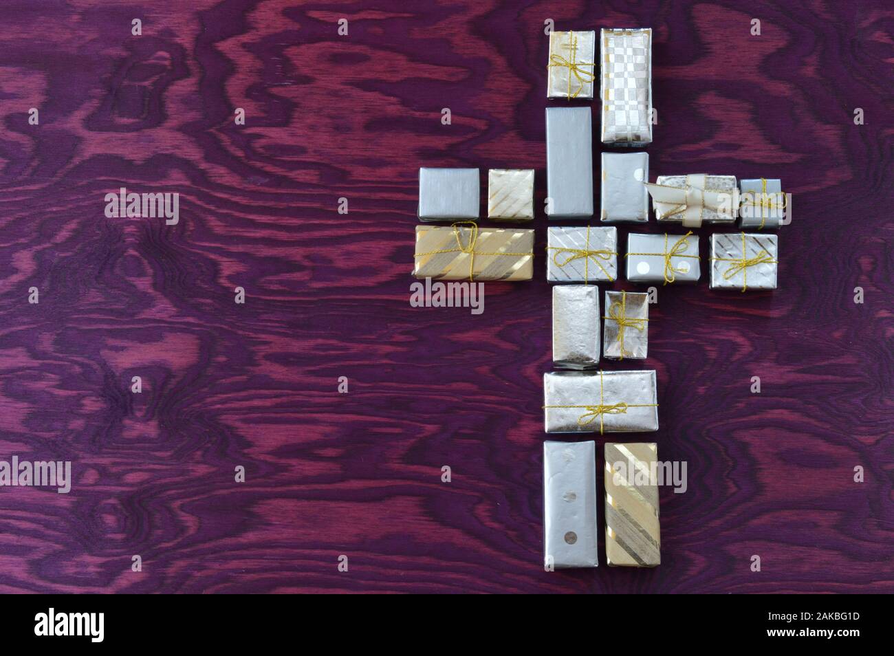 many little presents shaping a cross on purple wooden background Stock ...