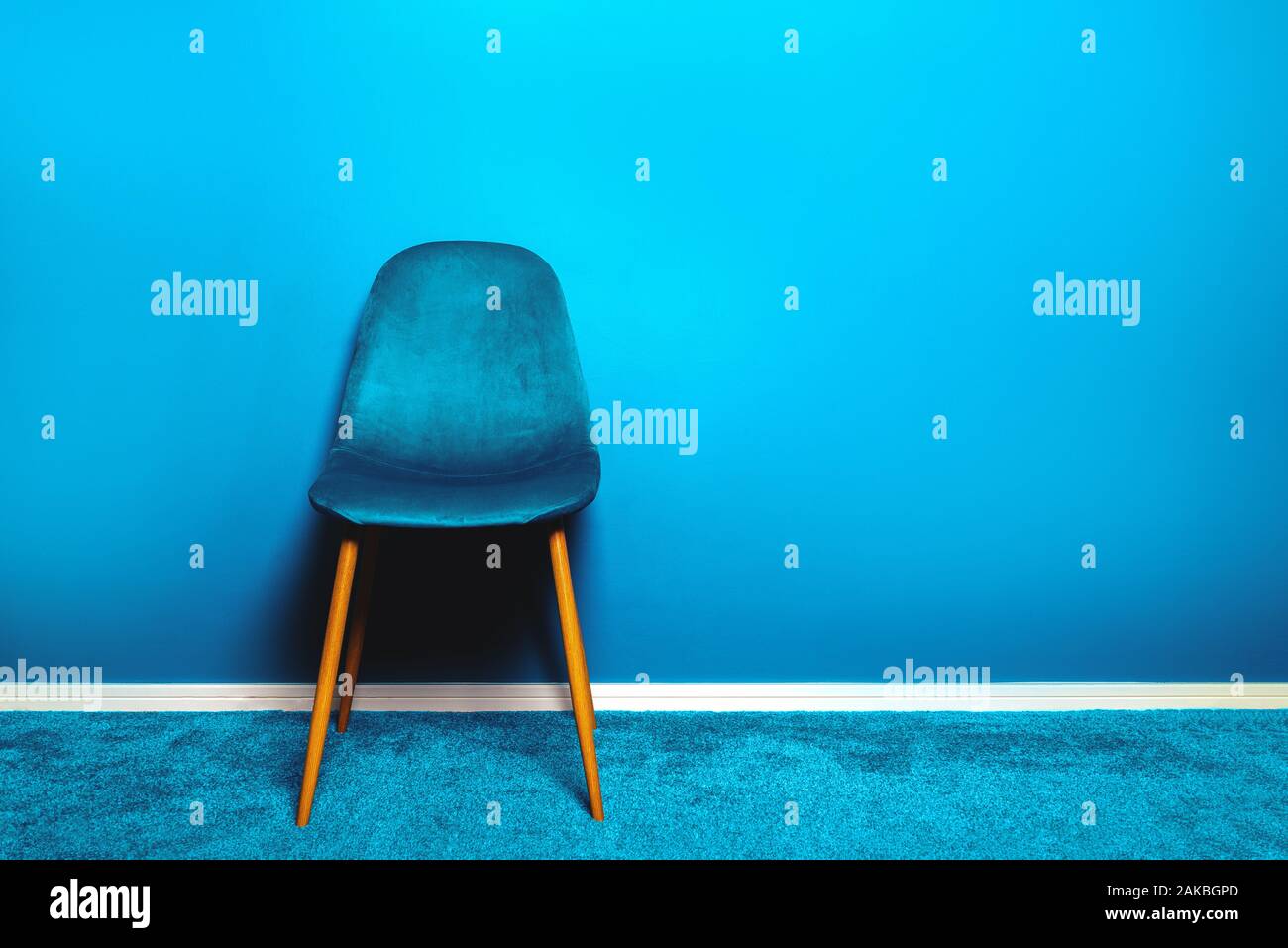 Modern Blue Velour Chair on wooden legs, blue background Stock Photo ...