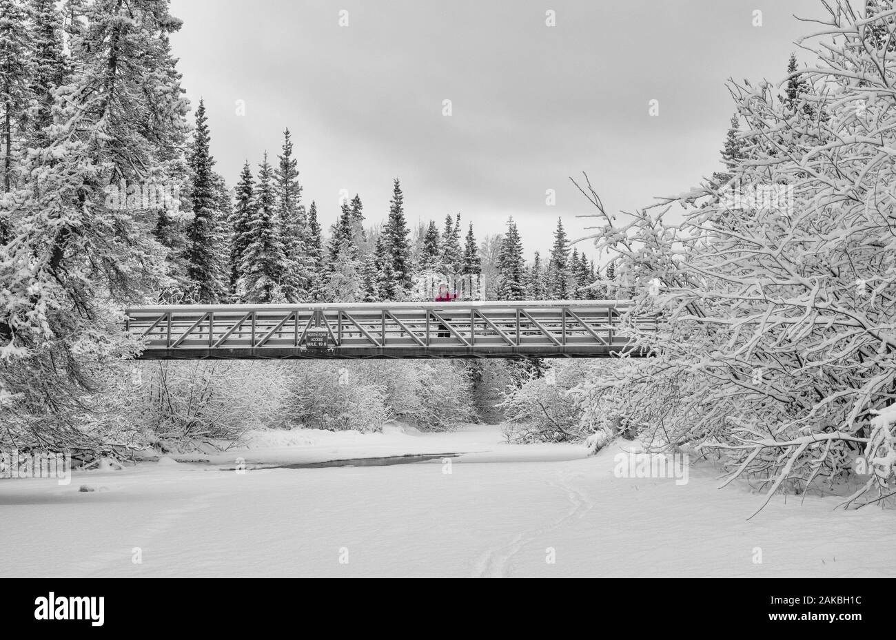 Woman standing on bridge over tributary of Eagle River in Southcentral ...