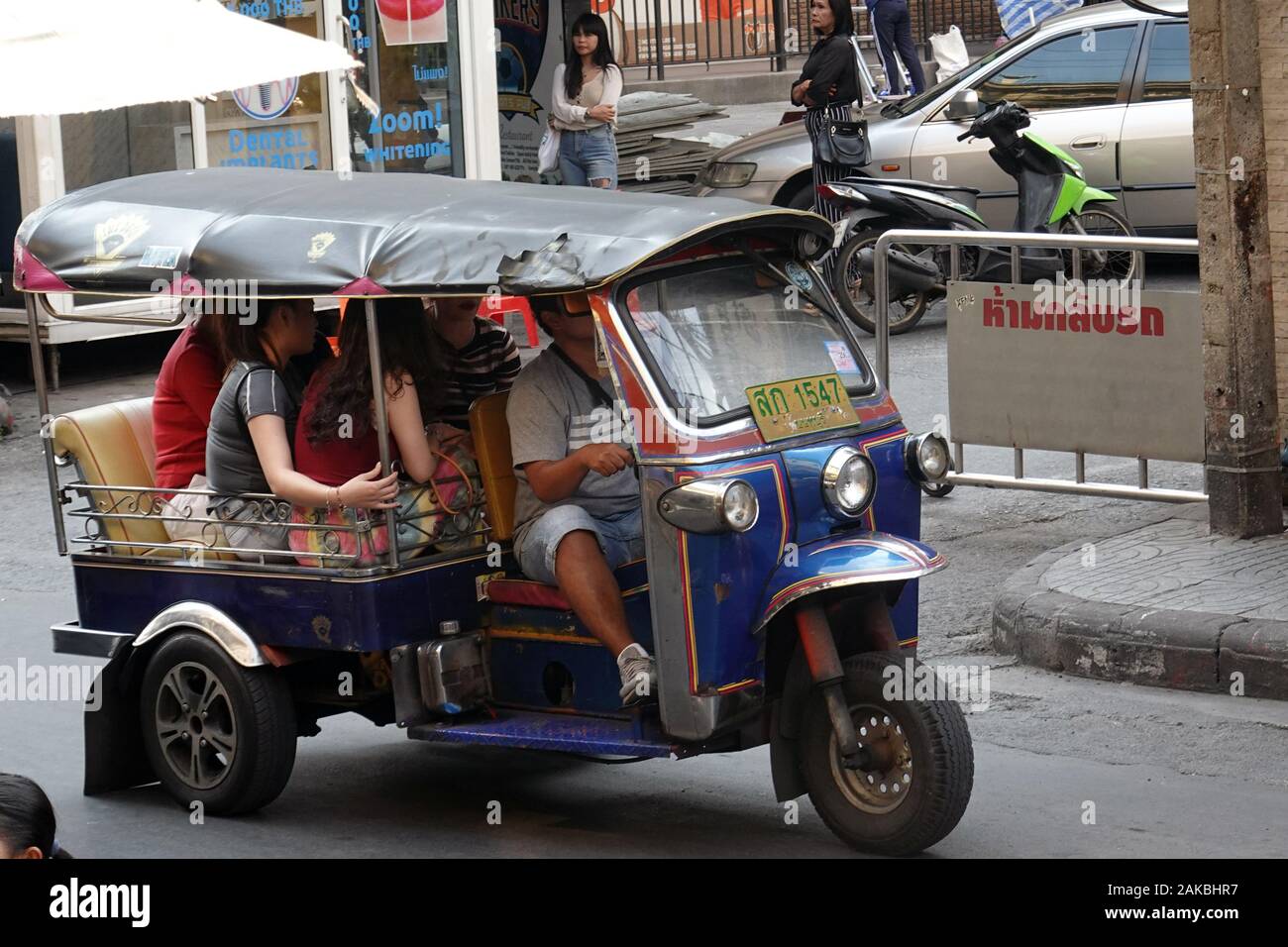 Bangkok, Thailand - December 26, 2019: Three wheeled tuk tuk taxi on a street with many ...