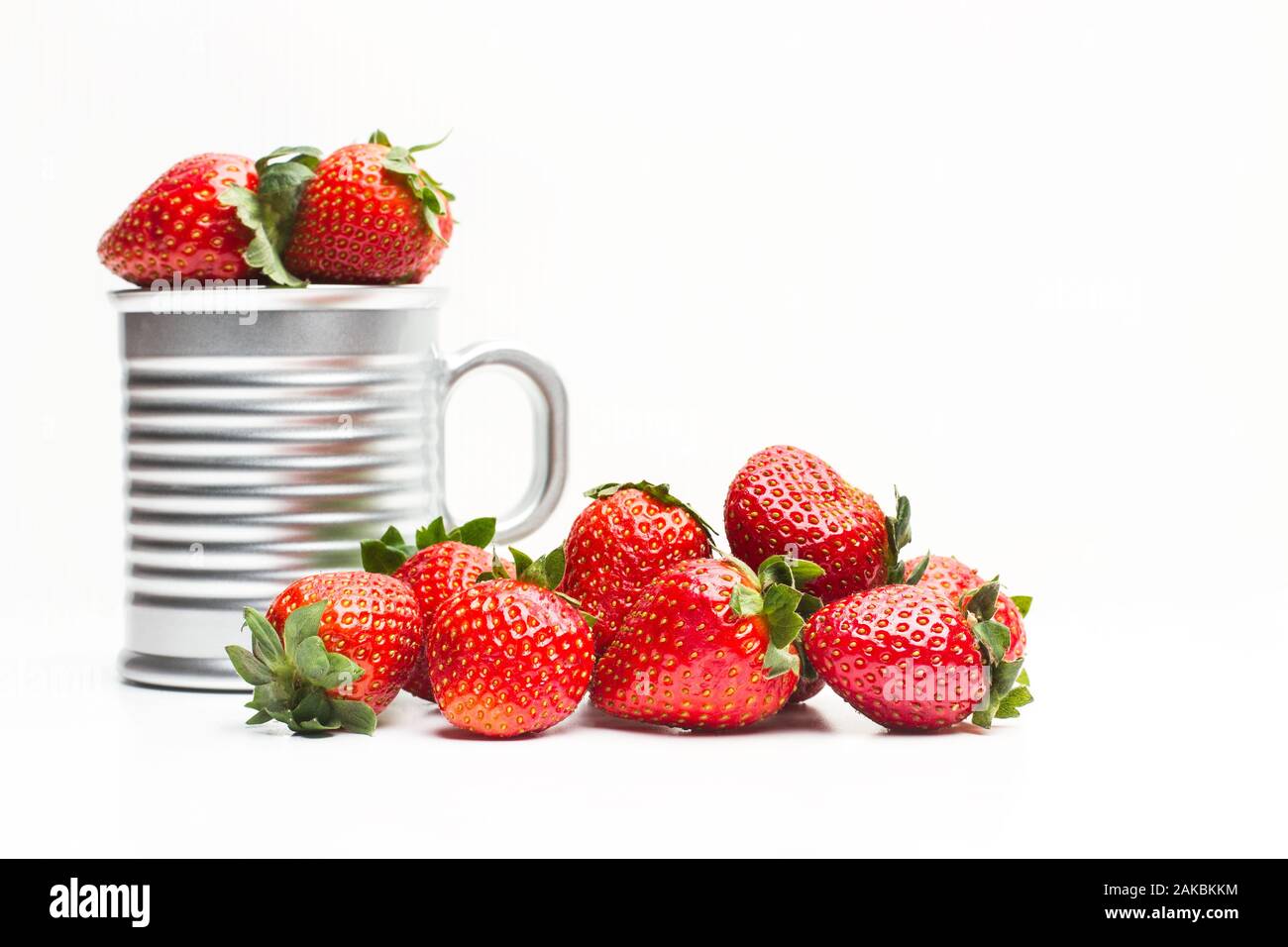 Red delicious strawberries in a mug and on a white background Stock ...