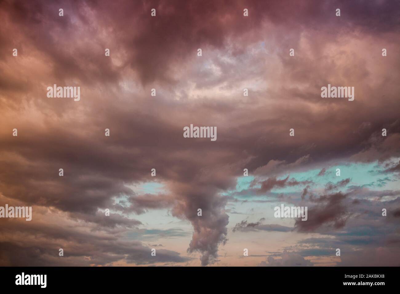 beautiful sunset and clouds in the shape of a vortex in dramatic colors ...