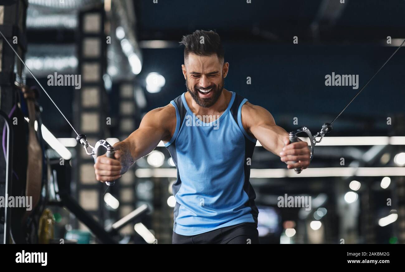 Triceps workout. Bodybuilder training with block exerciser at gym, free ...